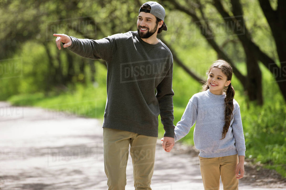 Smiling father pointing by finger to daughter in park - Royalty-free ...