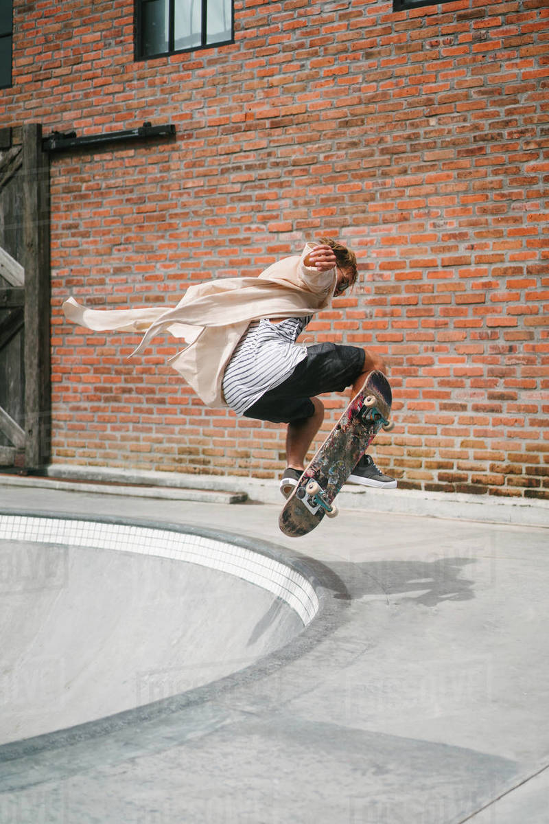 Handsome skater jumping from pool in skatepark - Royalty-free Stock ...