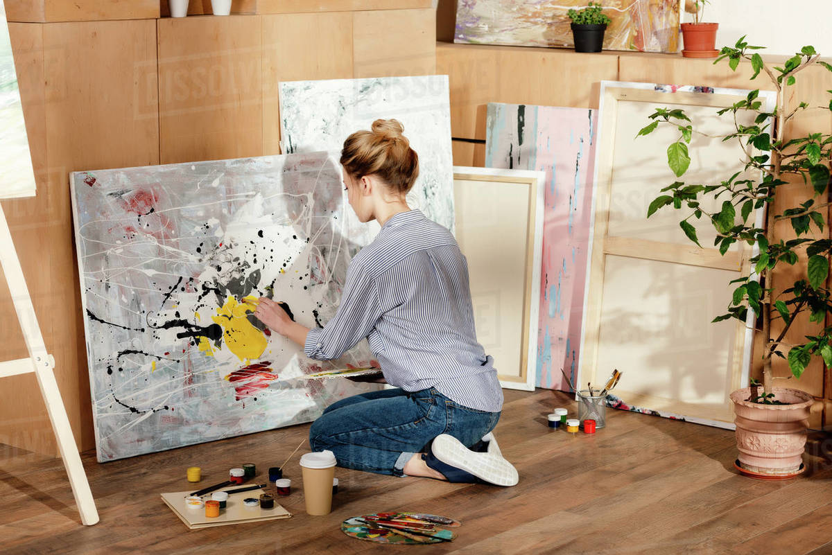 Back view of attractive girl painting in art studio - Royalty-free ...