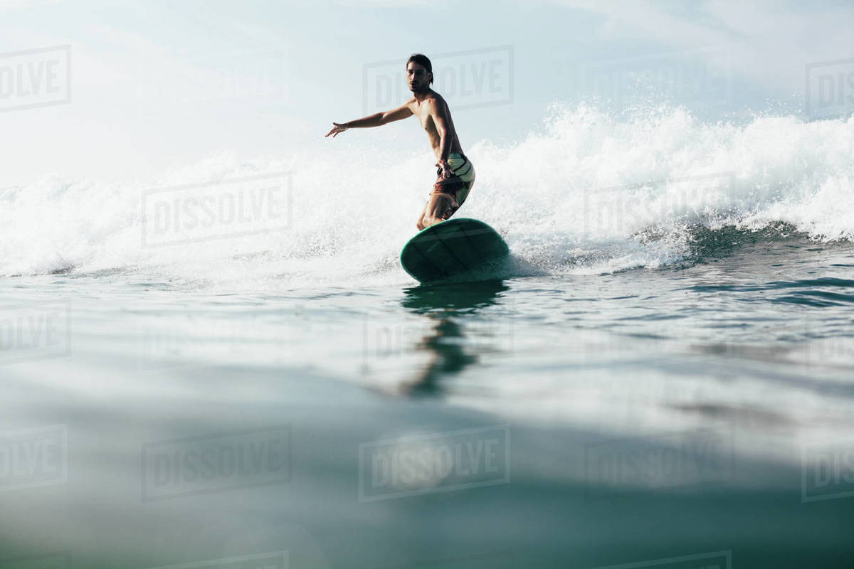 Handsome man riding waves on surfboard while having vacation - Royalty ...