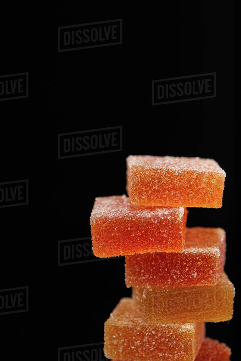 Close-up view of stack of jelly candies isolated on black background ...