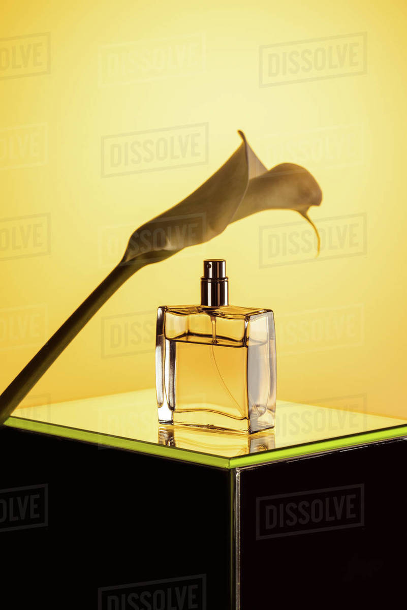 Spray bottle of perfume and calla flower, on yellow - Royalty-free ...