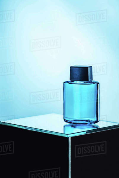 Mens perfume in blue spray bottle, on blue - Stock Photo - Dissolve