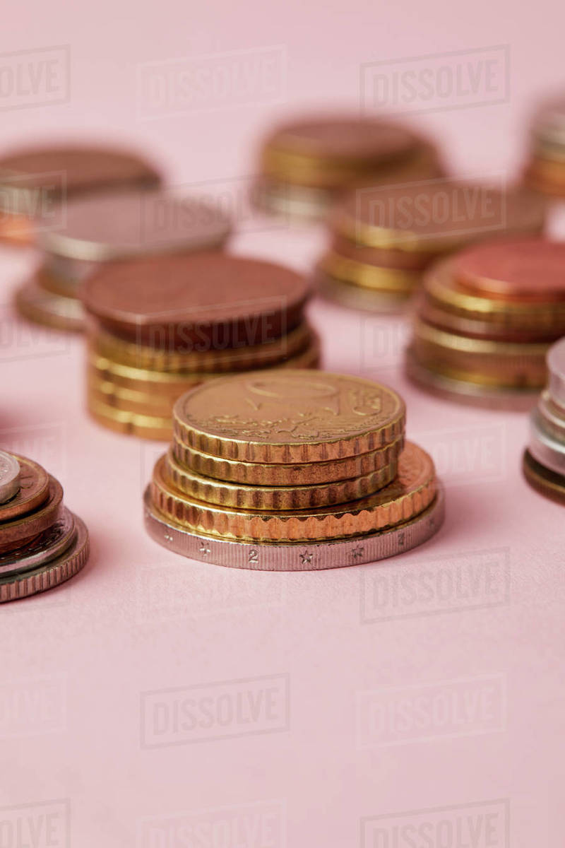 Close-up shot of stacks of coins from various countries on pink - Stock ...