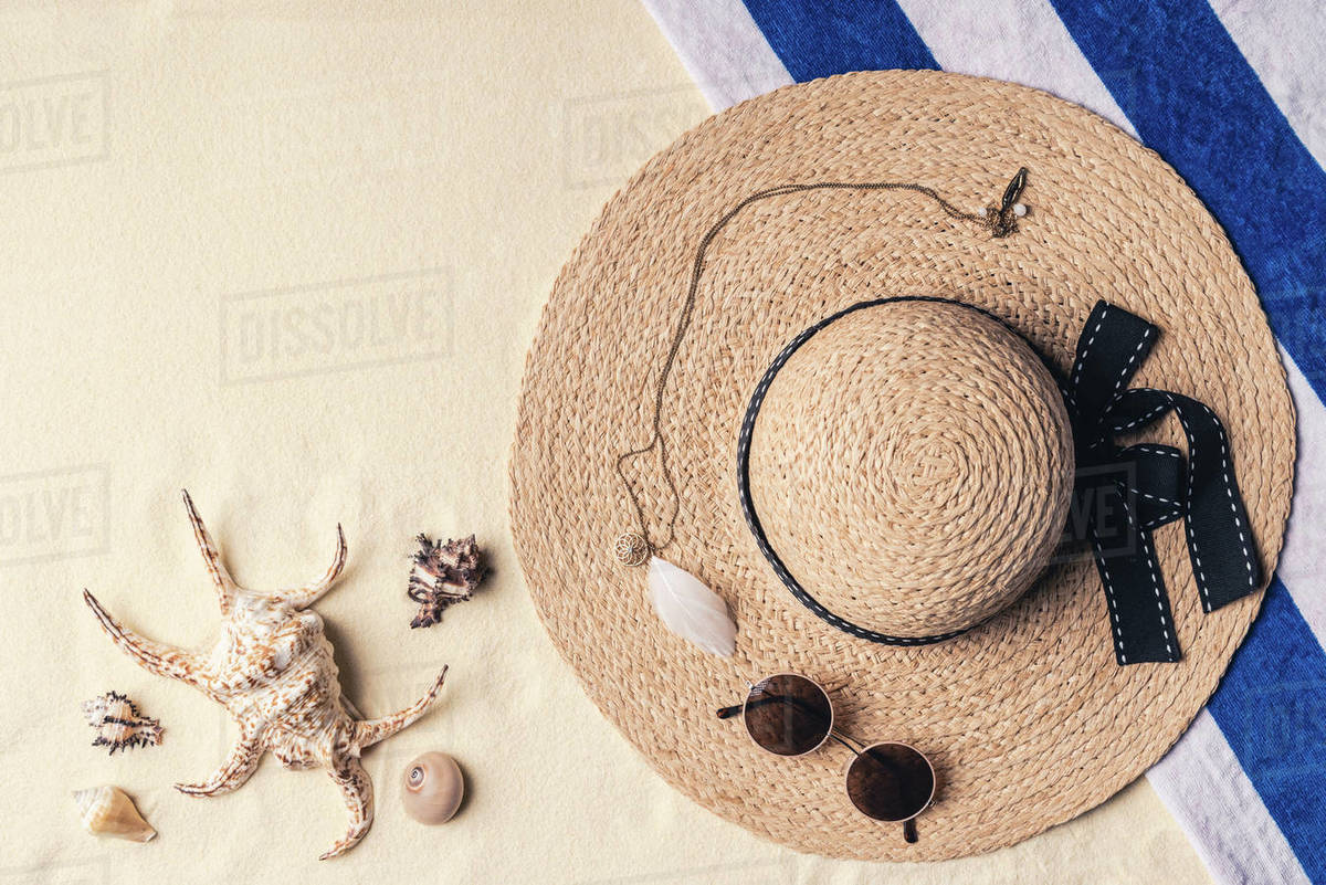 Straw hat with sunglasses and seashells on sandy beach - Royalty-free ...