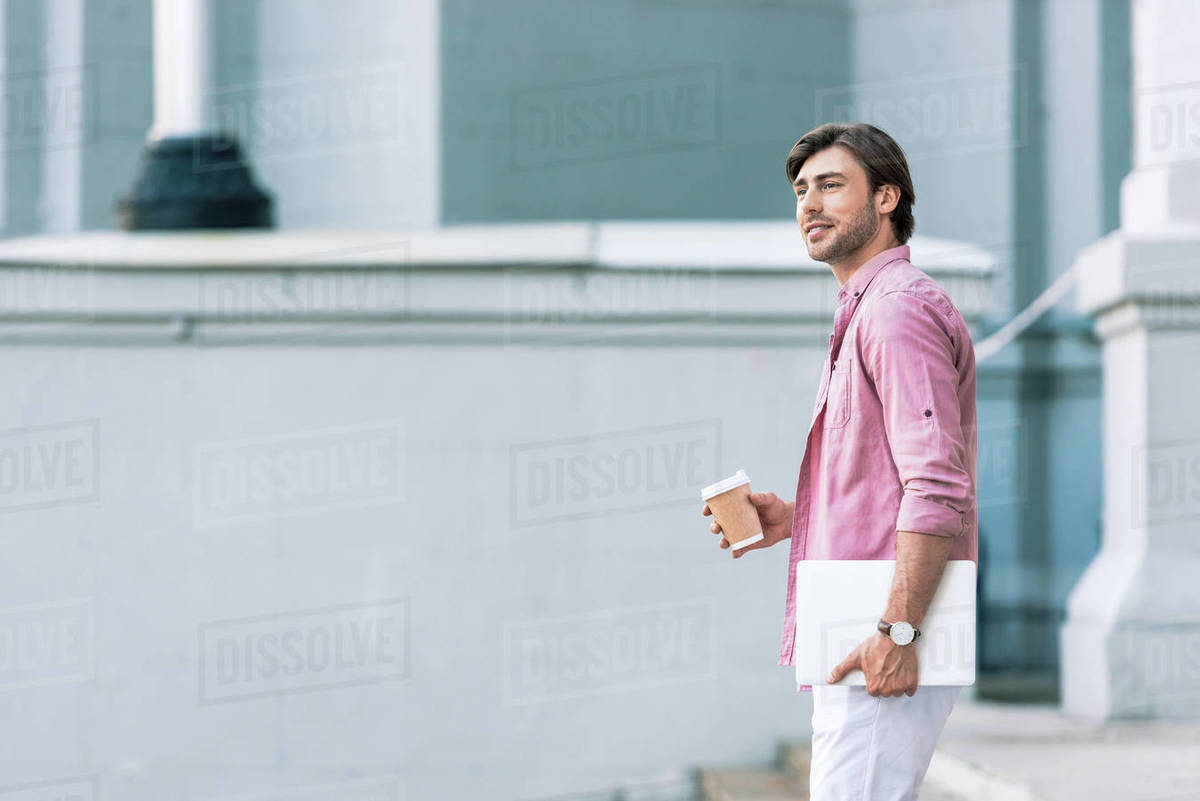 Side View Of Young Man With Laptop And Coffee To Go On Street Stock Photo Dissolve side-view-of-young-man-with-laptop-and-coffee-to-go-on-street-stock-photo-dissolve