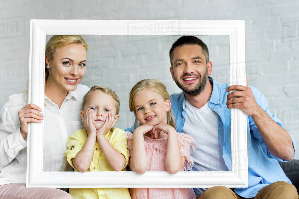 Happy family holding frame and smiling at camera - Royalty-free Stock ...