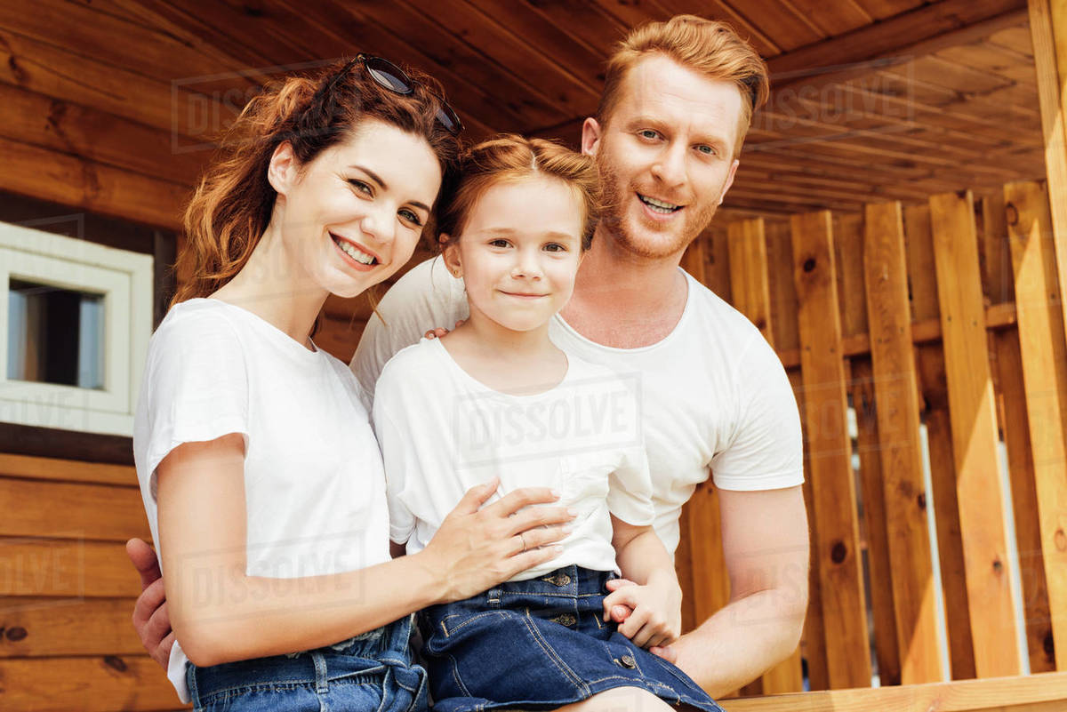 smiling european young family embracing and looking at camera - Royalty ...