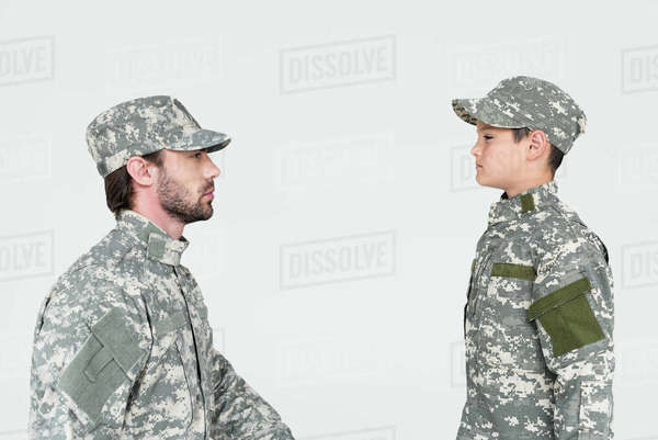 side view of soldier and son in military uniforms looking at each other ...