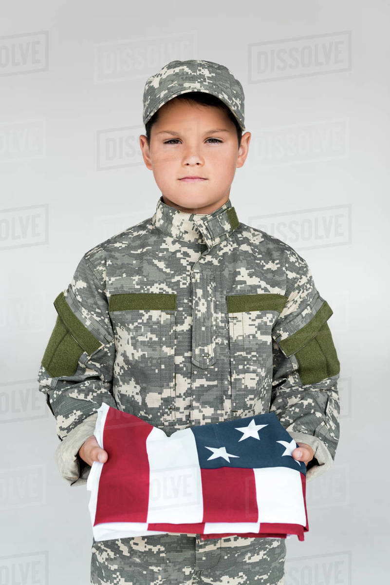 portrait of kid in military uniform holding folded american flag ...
