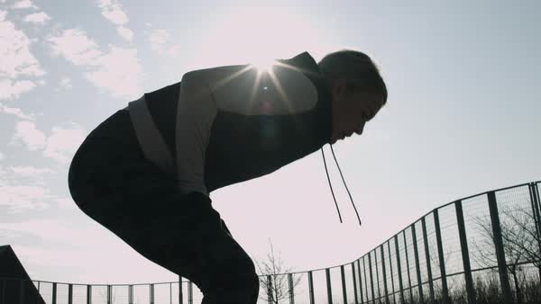 Athletic woman deep breathing and resting after an intense workout ...