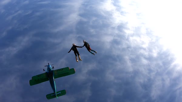 Freefly skydiving. Two skydivers are jumping out of biplane and falling ...
