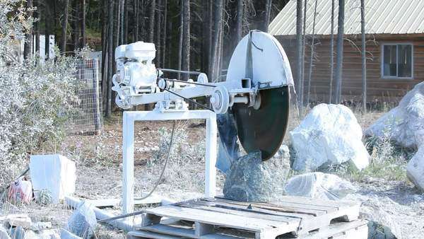Jade rock being cut with an electical slab saw to make beautiful ...