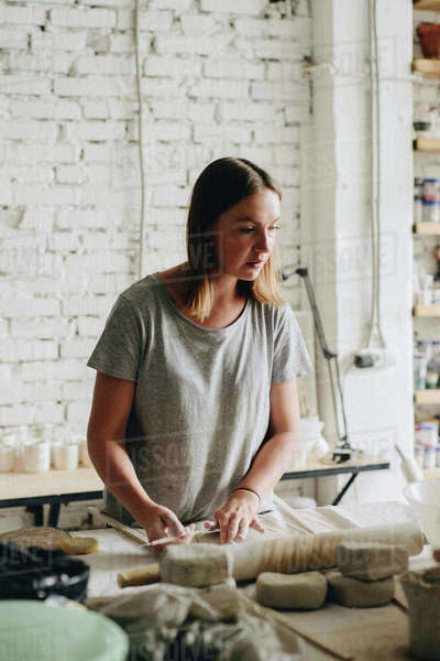 Female maker ceramics working with clay and creating a shape of ceramic ...