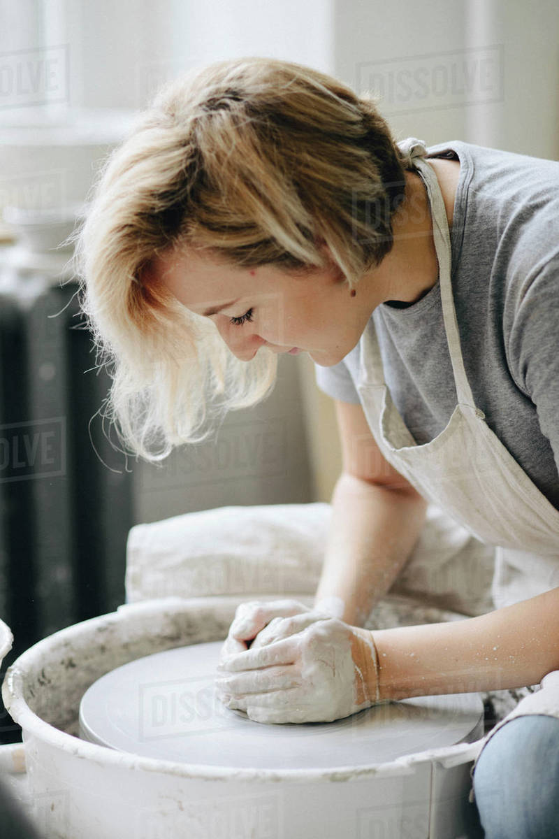 Ceramic working process with clay potter's wheel. Woman making pottery ...