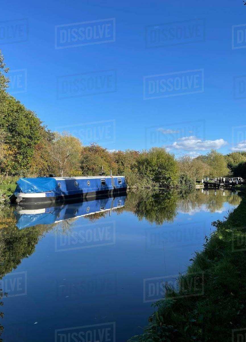 Narrowboat moored on Grand Union Canal with a lock in the distance ...
