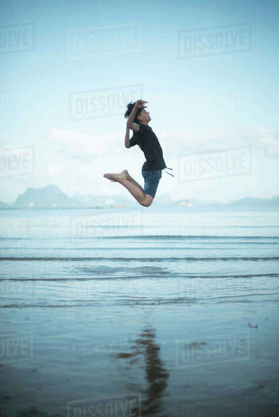 Teenage boy jumping in the air on the beach, Koh Yao, Phang Nga ...