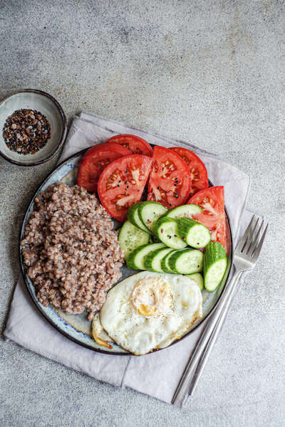 Overhead view of a healthy lunch plate with buckwheat, cucumber, tomato ...