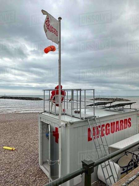 Lifeguard sitting on a lifeguard station in stormy weather, Sidmouth ...