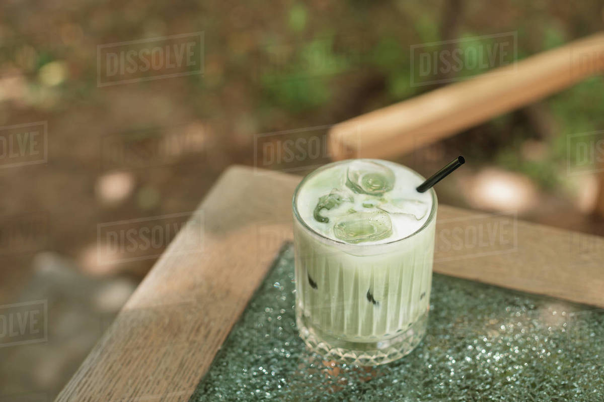 Close-up of an iced matcha latte drink on a table outdoors - Royalty ...