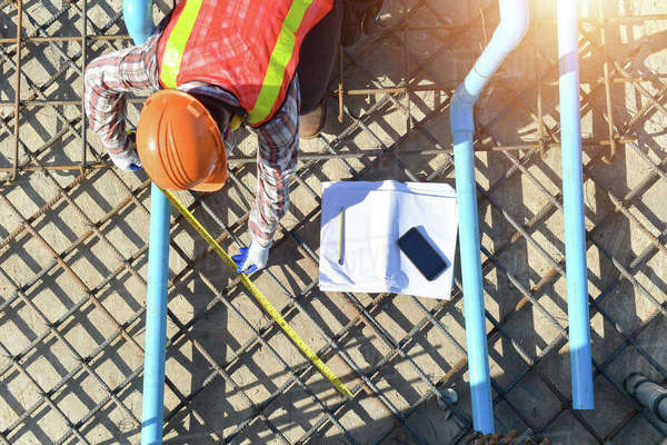 Overhead view of a building contractor checking foundations of a ...