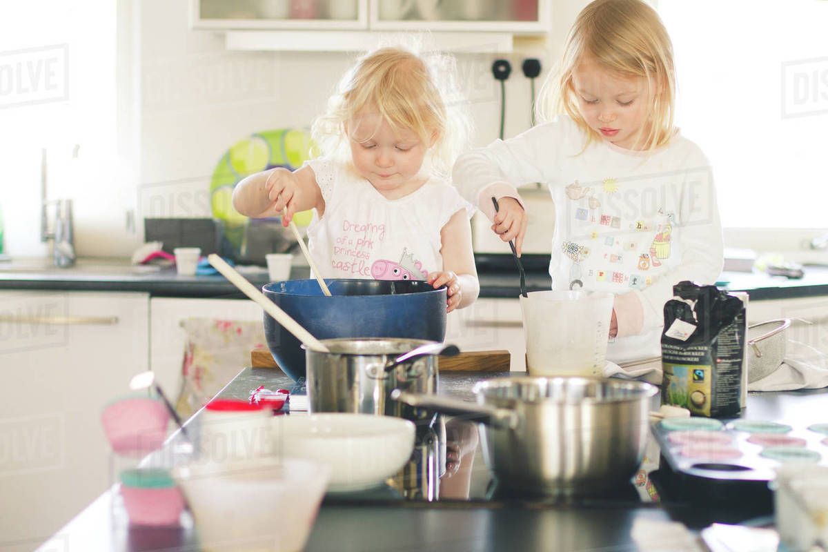 Two girls baking in the kitchen - Royalty-free Stock Photo | Dissolve
