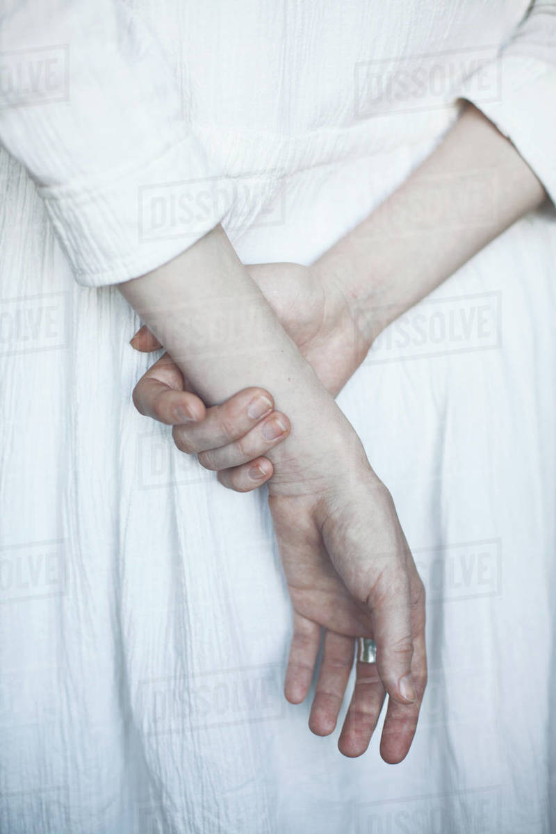 Rear view of woman holding hands behind her back - Royalty-free Stock ...