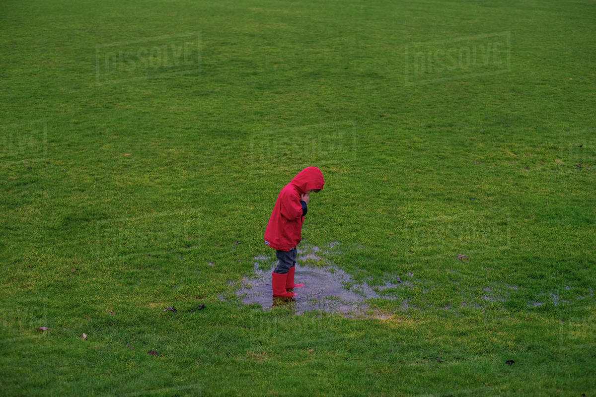 Elevated view of boy standing in a puddle - Royalty-free Stock Photo ...