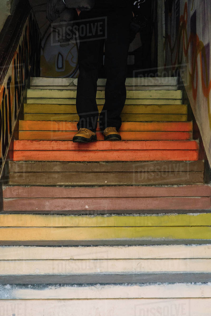 Boy walking down multi-colored steps - Stock Photo - Dissolve