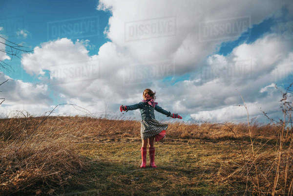 Girl standing with outstretched arms in the wind - Royalty-free Stock ...