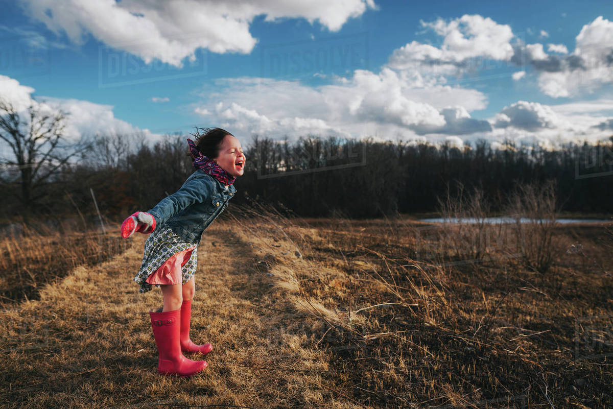 Girl with arms outstretched shouting into the wind - Royalty-free Stock ...
