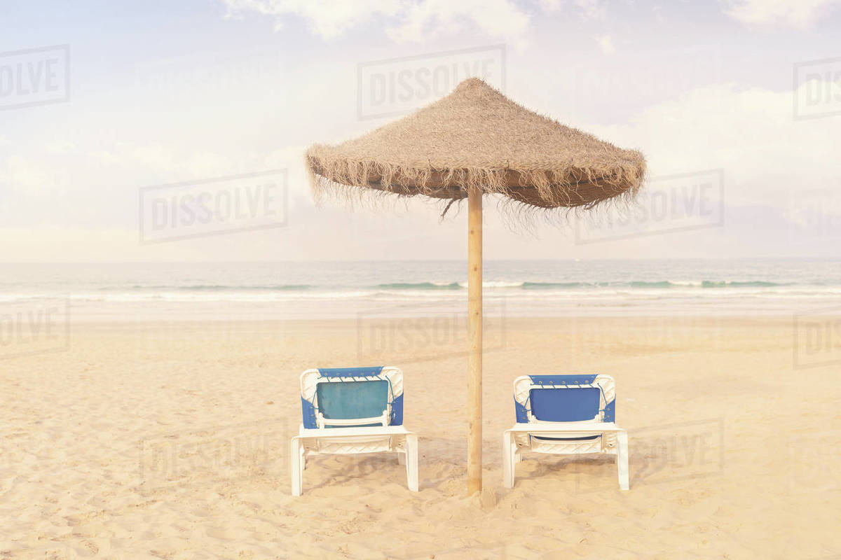 Two sun loungers and a parasol on beach - Royalty-free Stock Photo ...