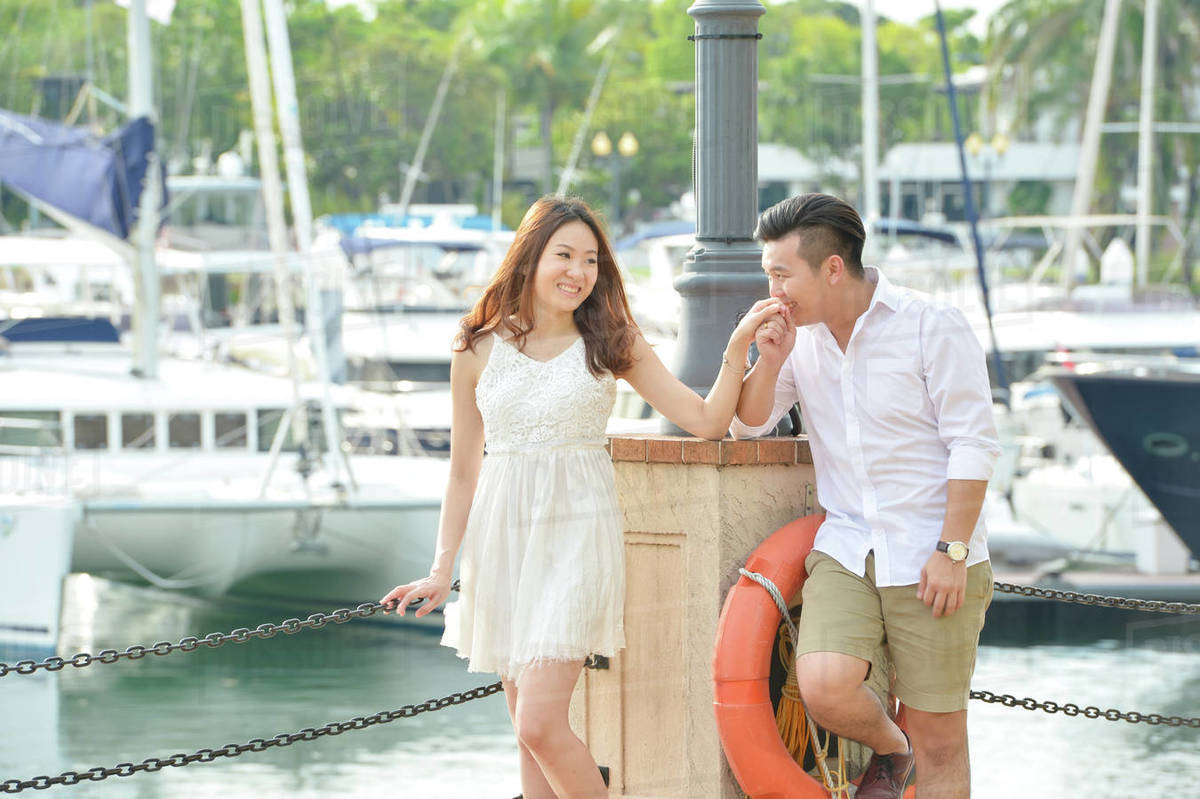 Portrait of a couple in love standing by a marina, Singapore - Royalty ...