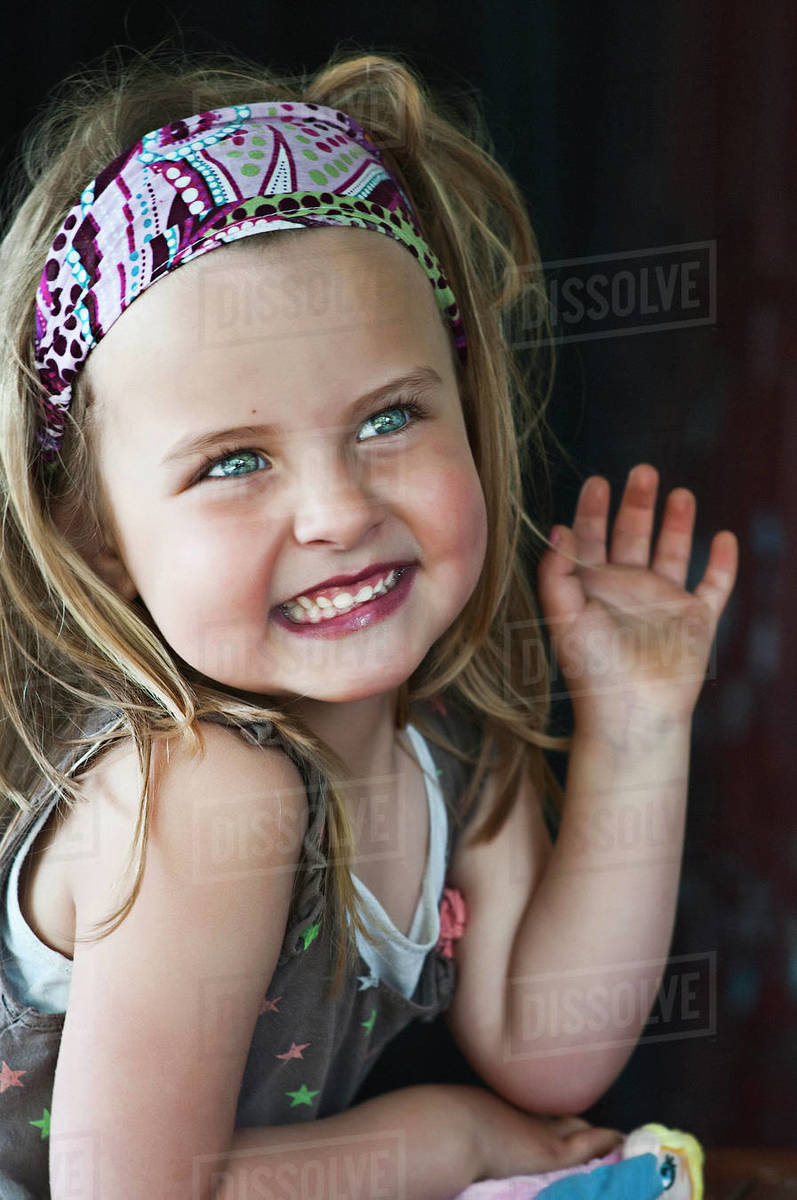 Portrait of a smiling girl waving - Royalty-free Stock Photo | Dissolve