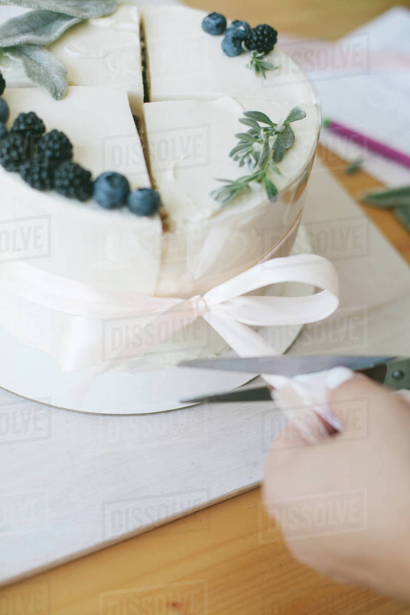 Woman tying together four slices of cake to make a compound cake ...
