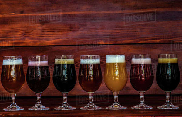 A row of assorted craft beers lined up on a table - Stock Photo - Dissolve
