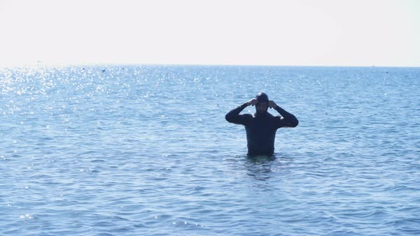 Free diver in wetsuit preparing to dive underwater in sea - Stock Video ...