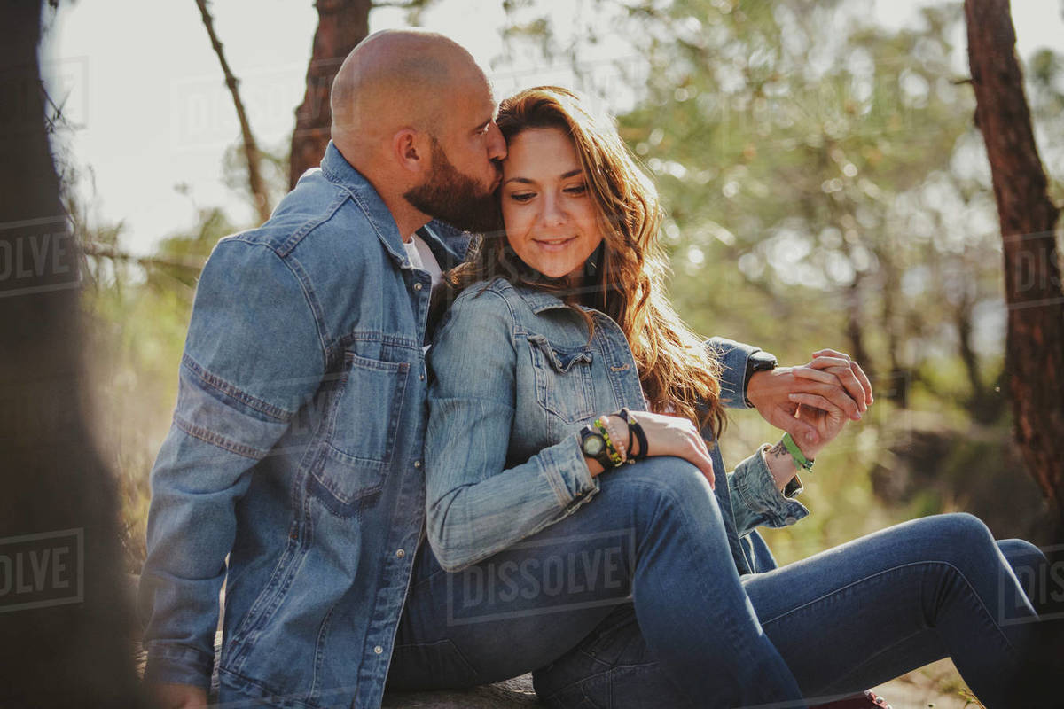 Sensual couple embracing while sitting at mountain valley - Royalty ...