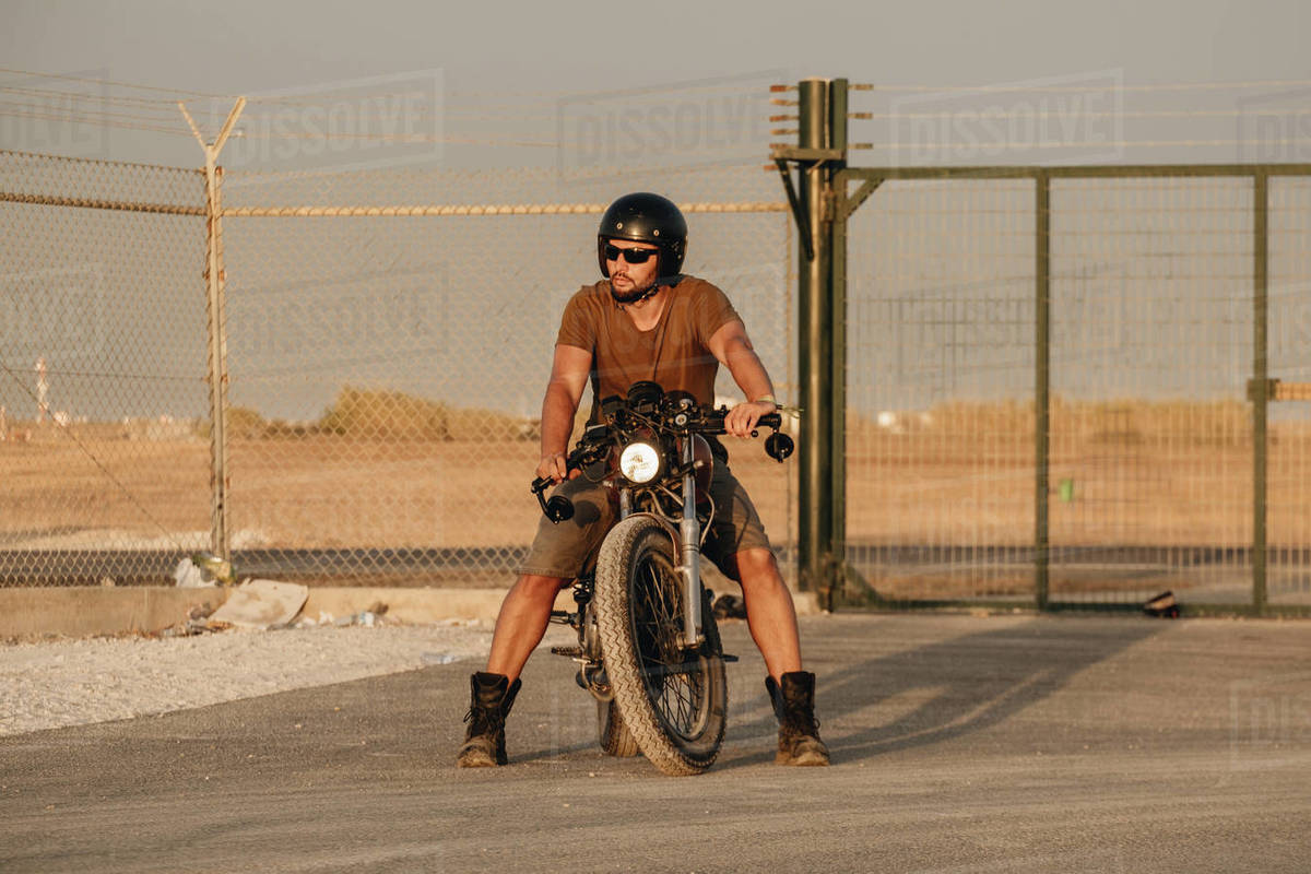 Strong man driving motorcycle - Stock Photo - Dissolve