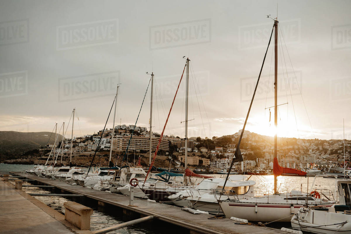 Sea port with white yachts and boats in city with buildings on hills at ...