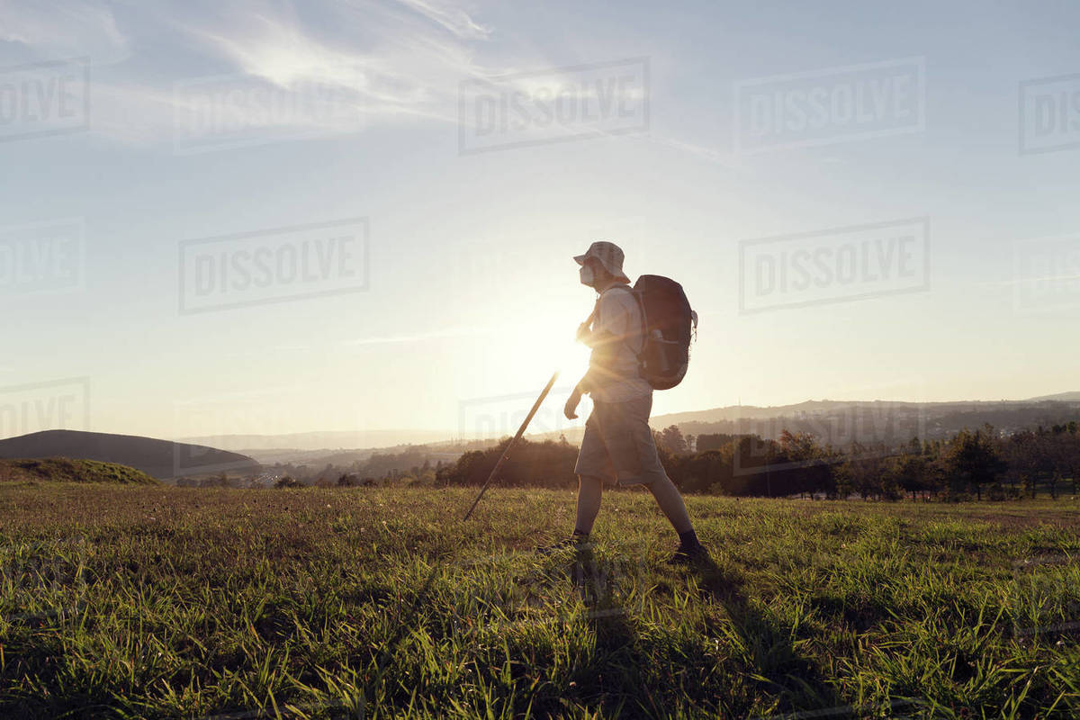 Side view of unrecognizable male pilgrim with rucksack and trekking ...