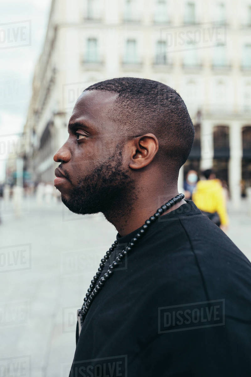 Side view portrait of serious black man looking away in urban scenery ...