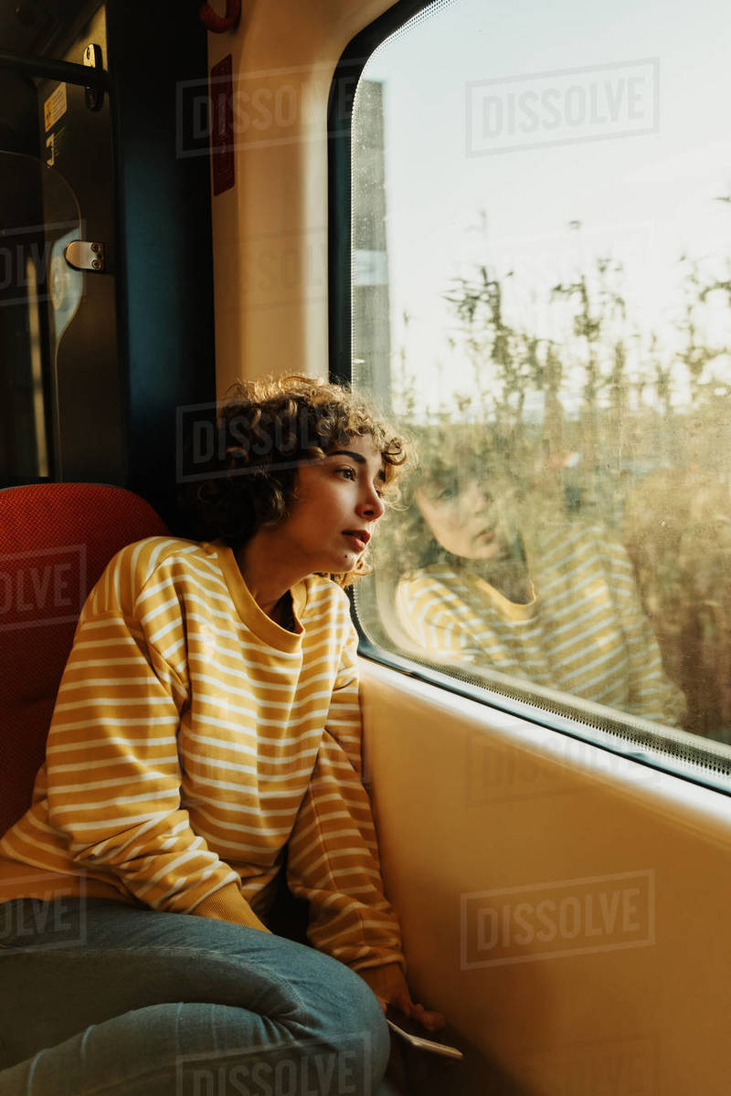 Young woman looking out train window - Royalty-free Stock Photo | Dissolve