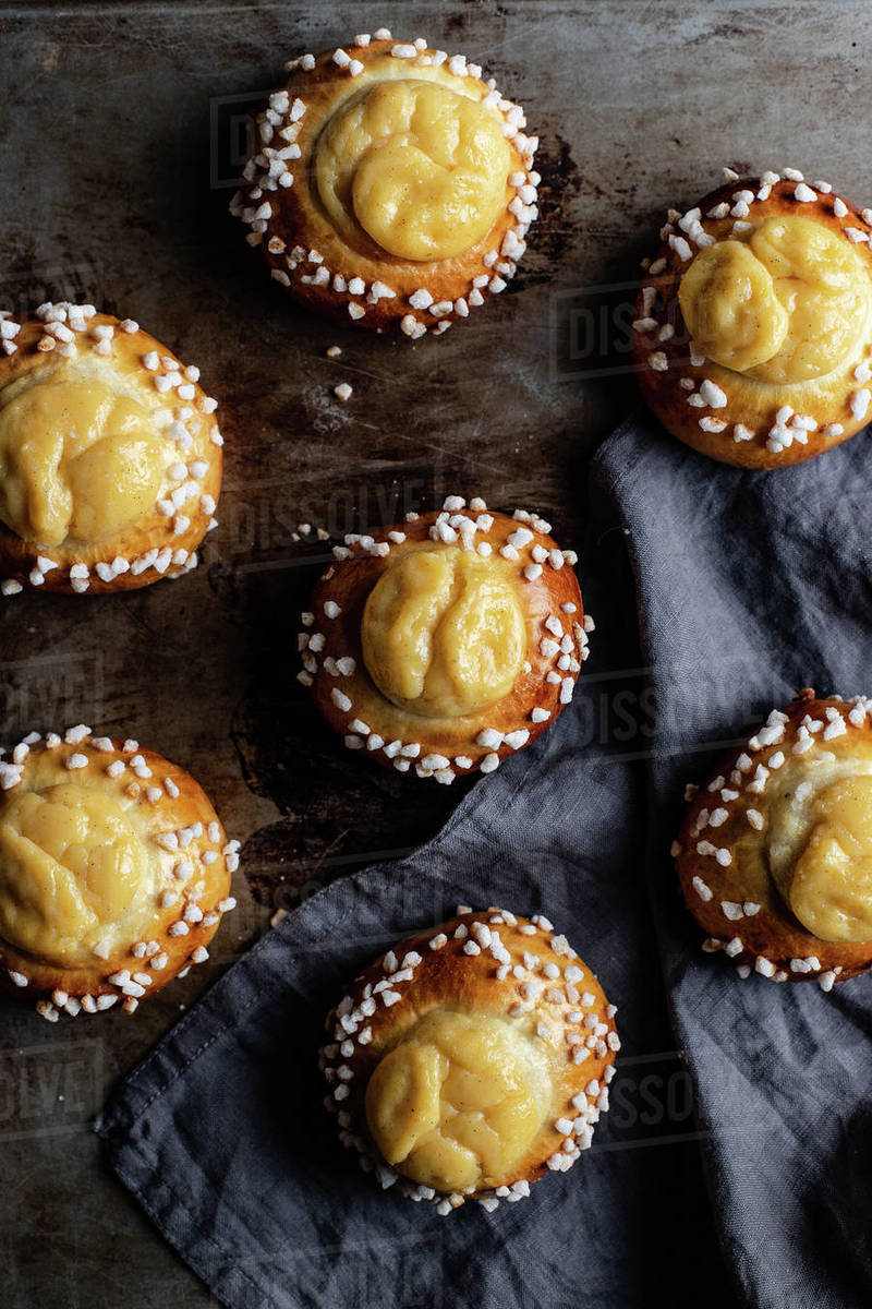 Top view of tasty fresh homemade buns with cream and sprinkles placed ...