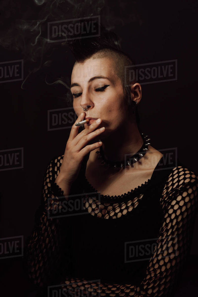 Adult female with mohawk and piercing smoking cigarette - Royalty-free ...