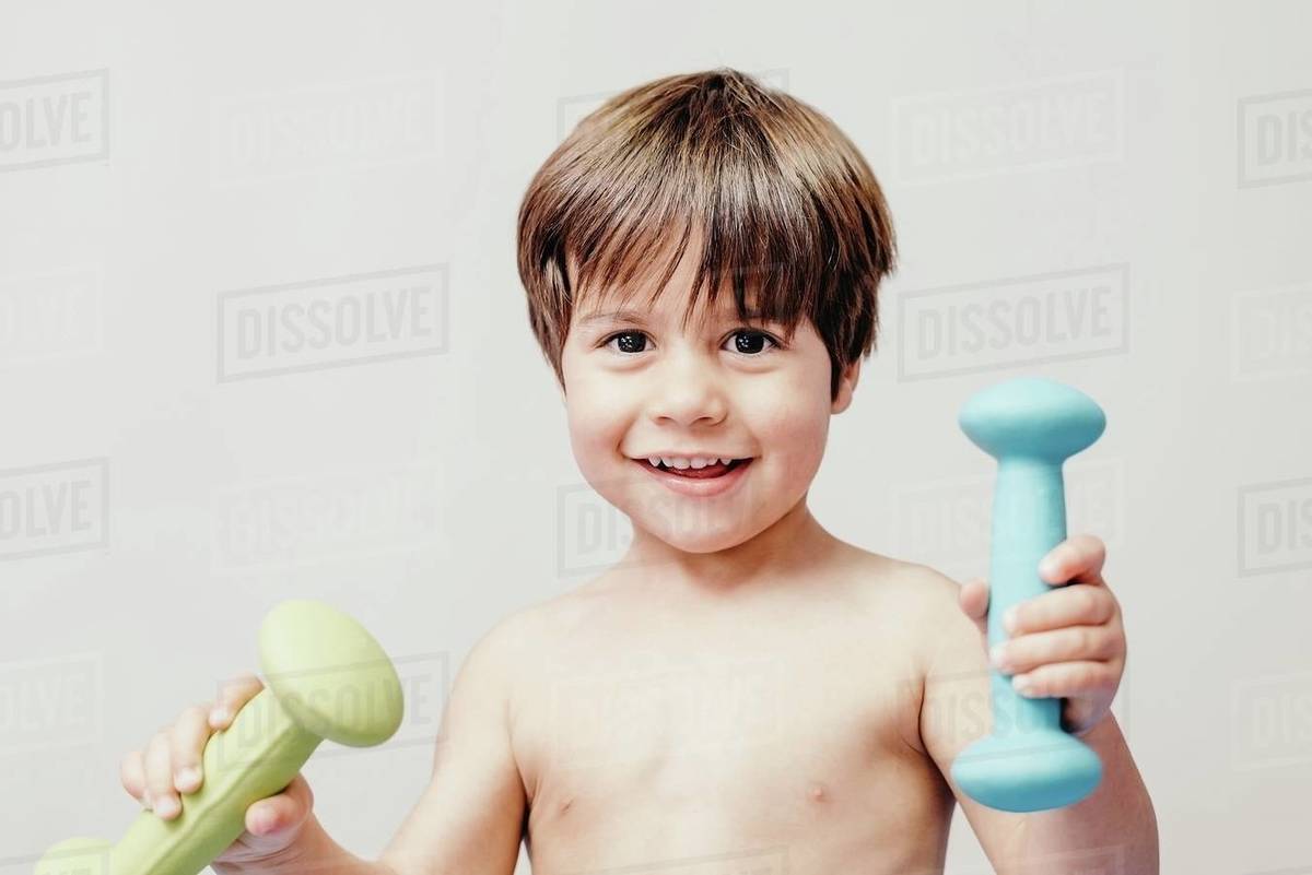 Cheerful little boy with dumbbells - Royalty-free Stock Photo | Dissolve