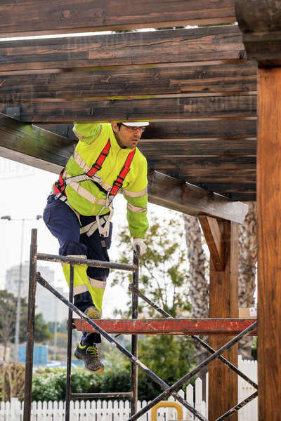 From below side view of male technician in work wear standing on ...