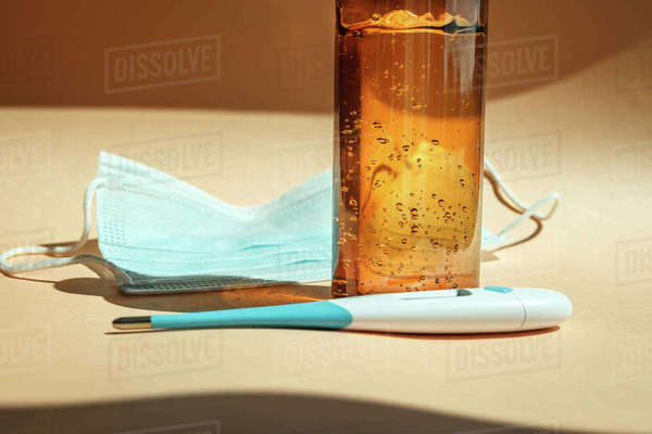 Glass of antiseptic liquid and forensic face respirator mask placed ...