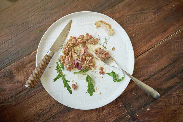 Top view of dirty half empty plate after delicious Steak tartare placed ...