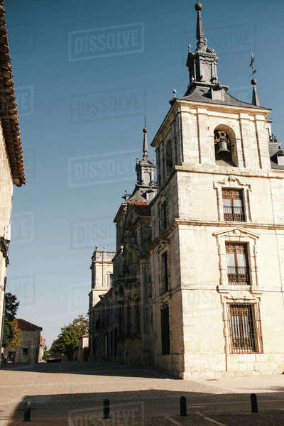 Low angle exterior of aged stone monastery building with bell tower ...